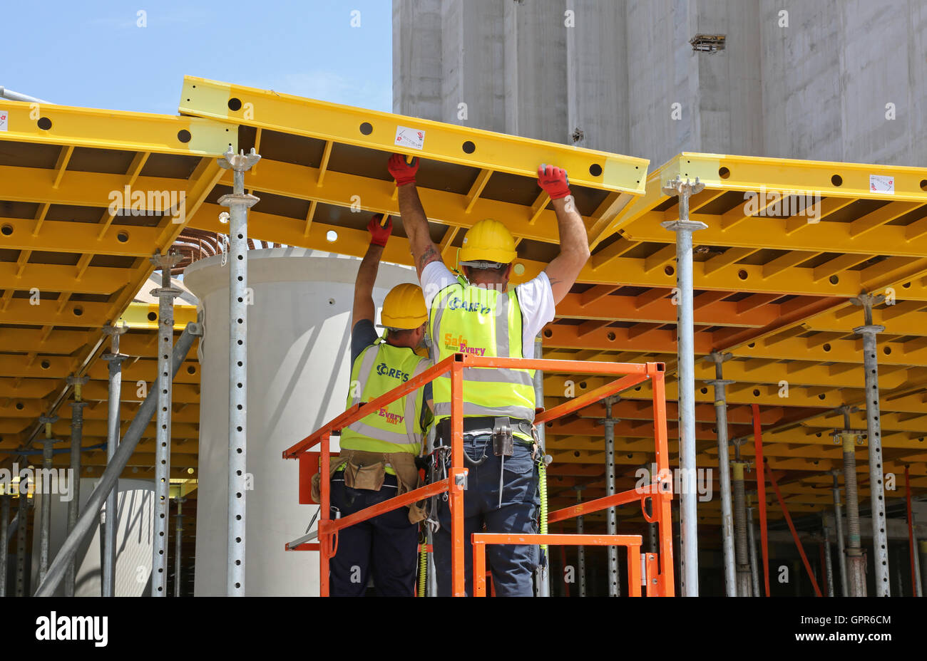 Construction workers install formwork for a concrete floor slab on a ...