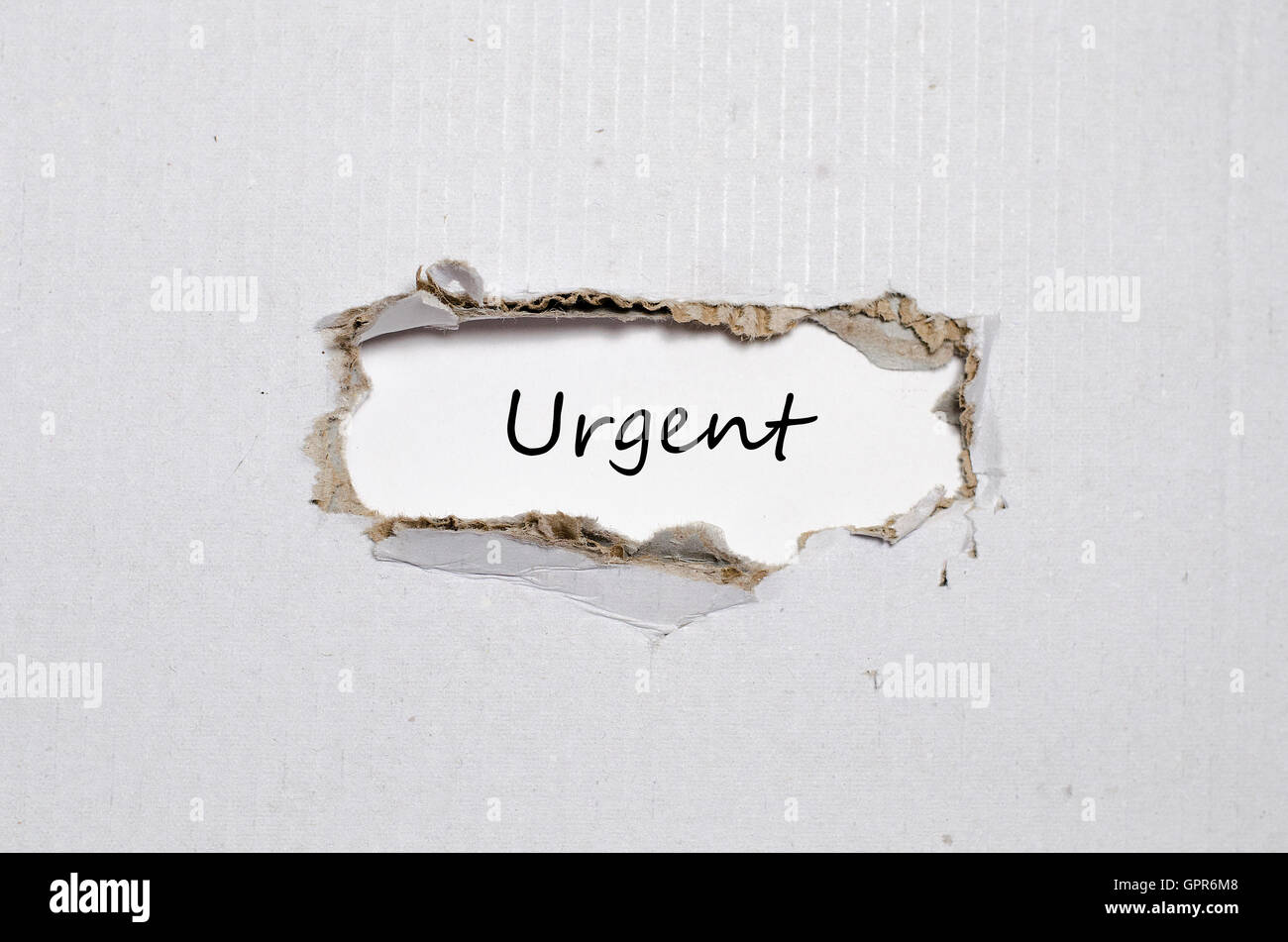 The word urgent appearing behind torn paper Stock Photo - Alamy