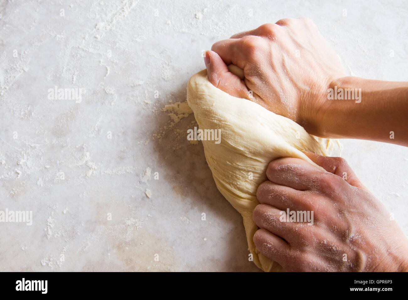 Hands kneading dough on white table Stock Photo - Alamy