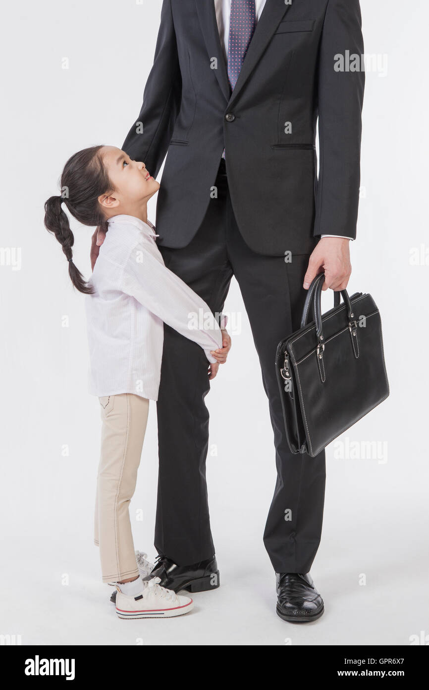 Smiling daughter hugging her father's leg Stock Photo - Alamy