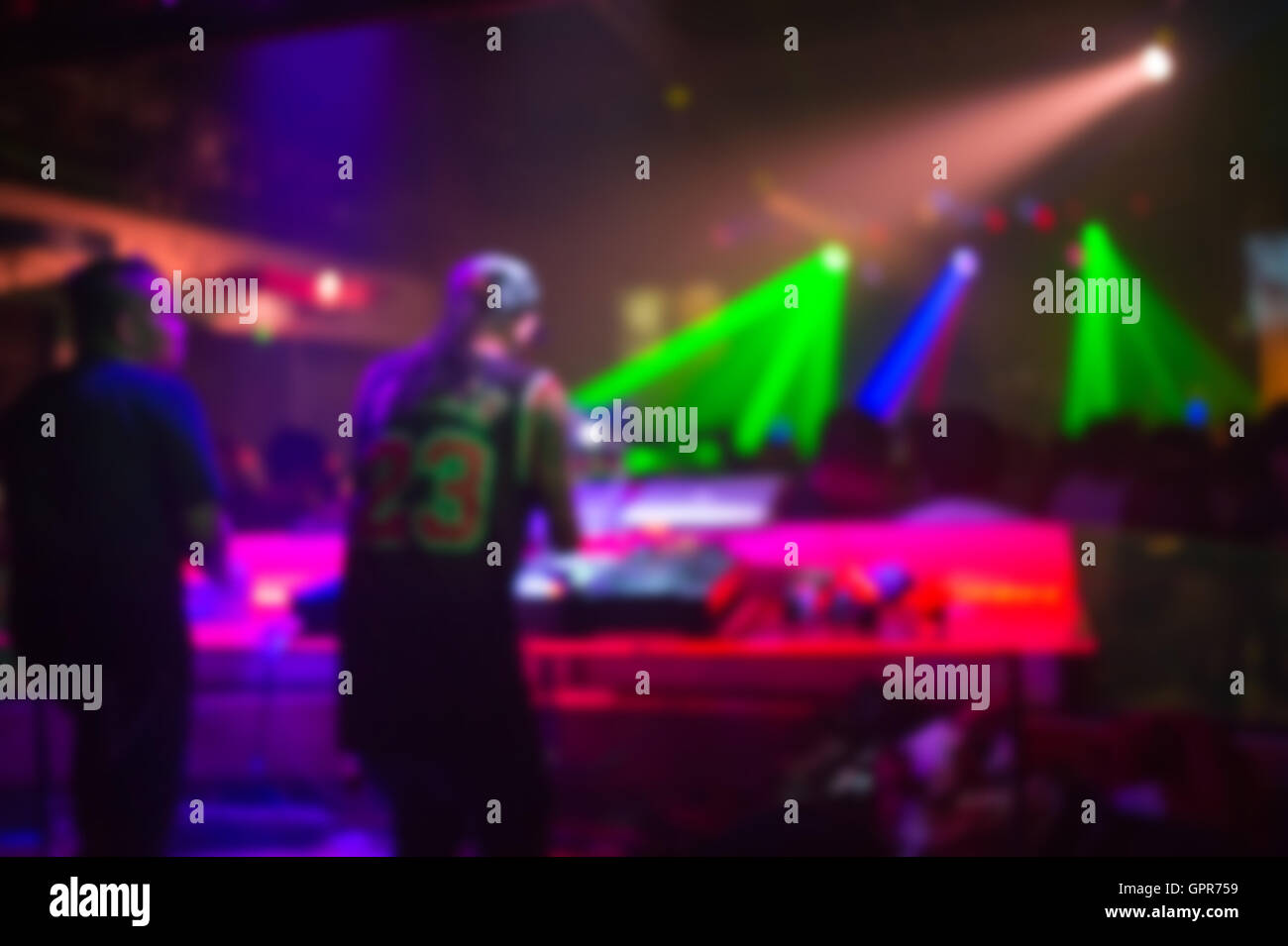 Blurred background : Club, disco DJ playing and mixing music for crowd ...