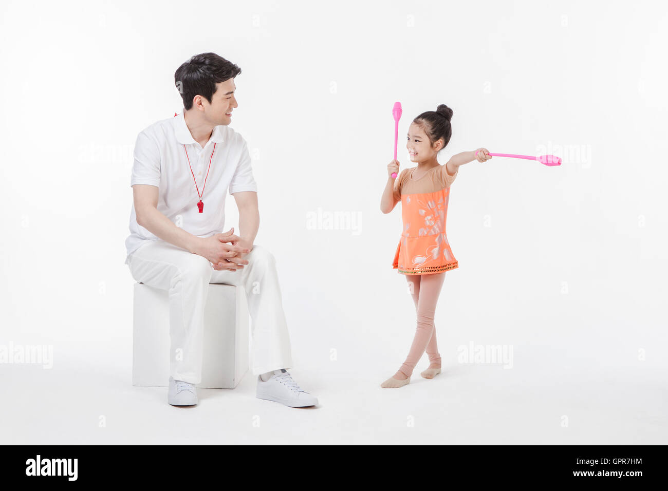 Smi coach and rhythmic gymnast with clubs Stock Photo - Alamy