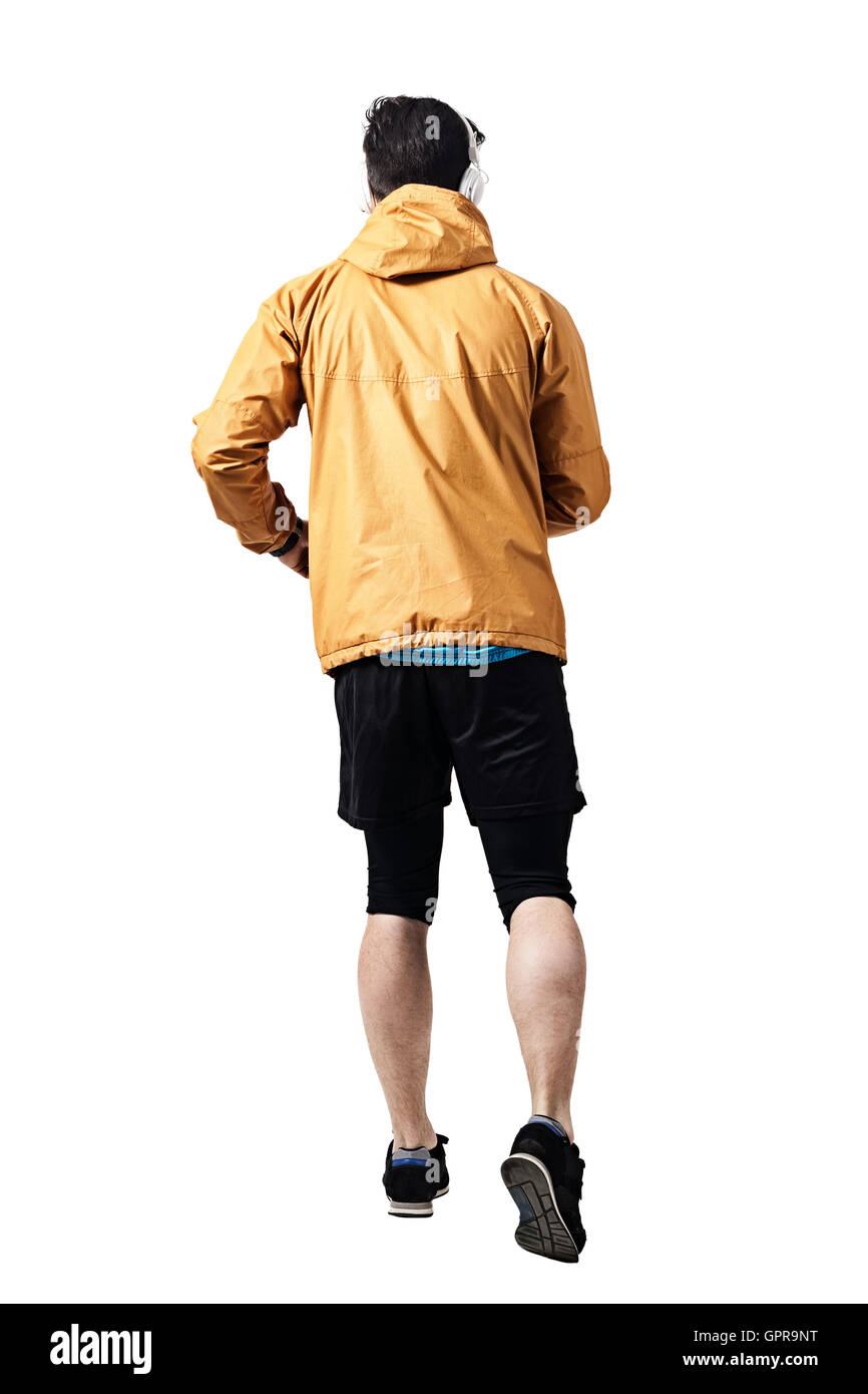 Back view of jogger in jacket running. Toned desaturated full body ...