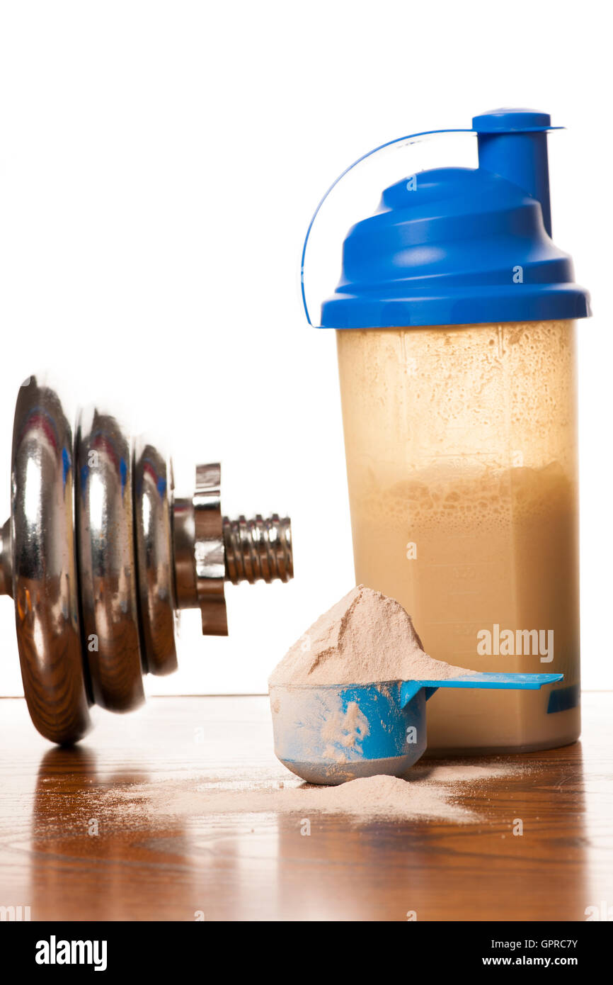 Whey protein powder in scoop, dumbbell, meter tape and plastic shaker ...