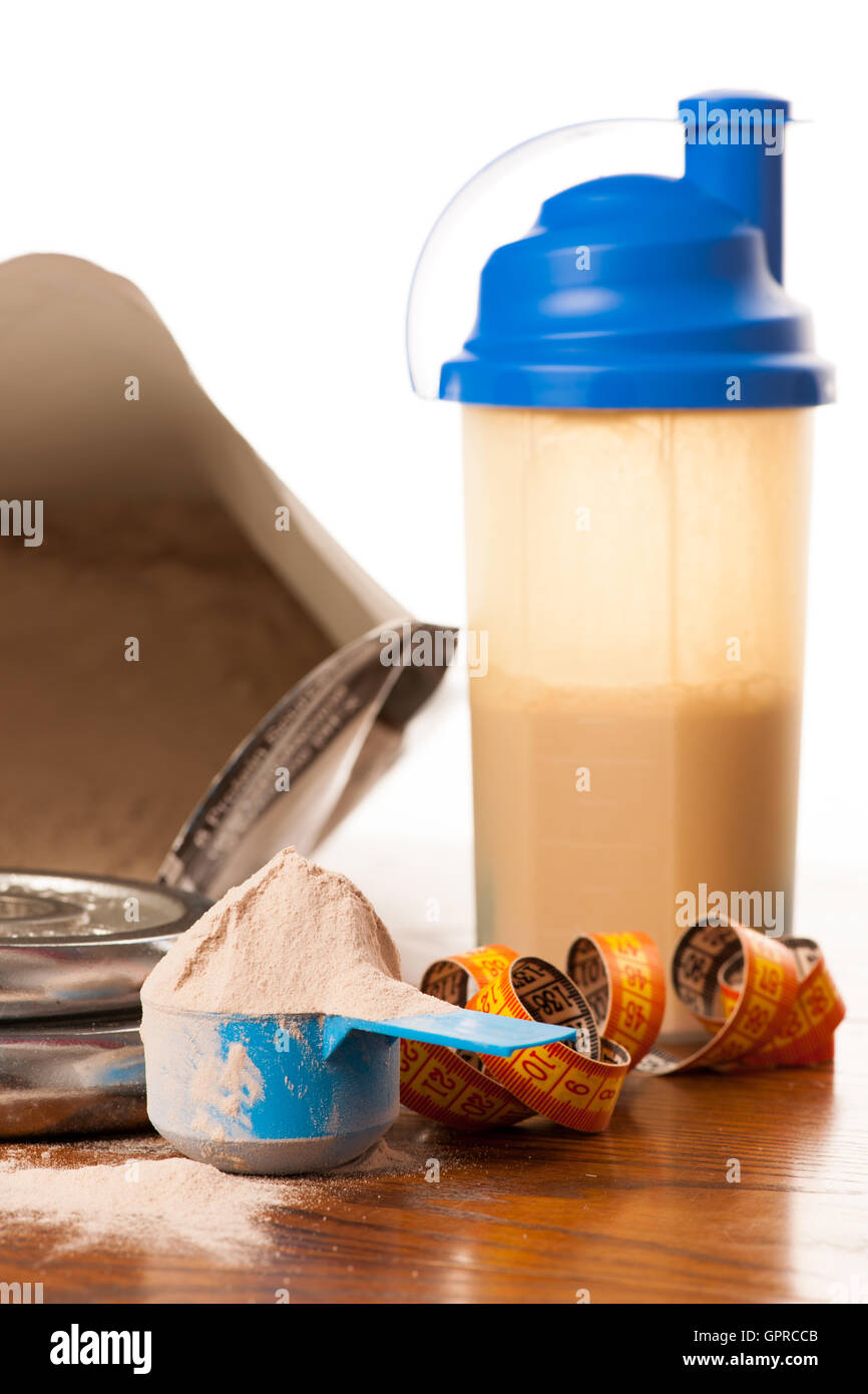 Whey protein powder in scoop, dumbbell, meter tape and plastic shaker ...