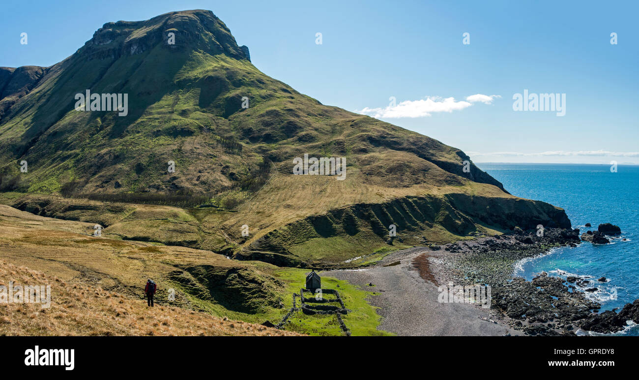 A walker approaching Guirdil Bay with Bloodstone Hill above Guirdil ...