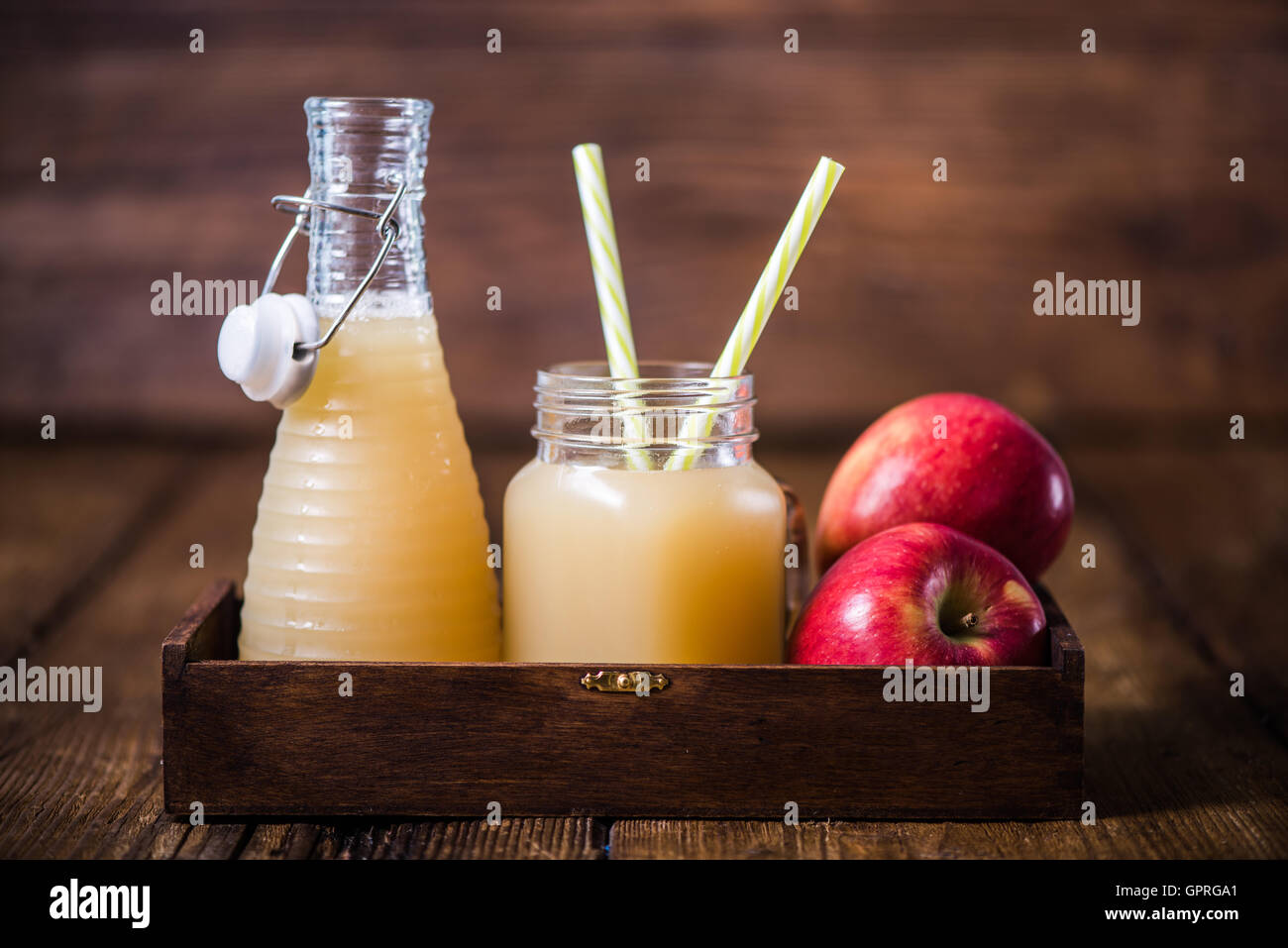 Apple cold pressed juice and fruits in wooden box Stock Photo - Alamy