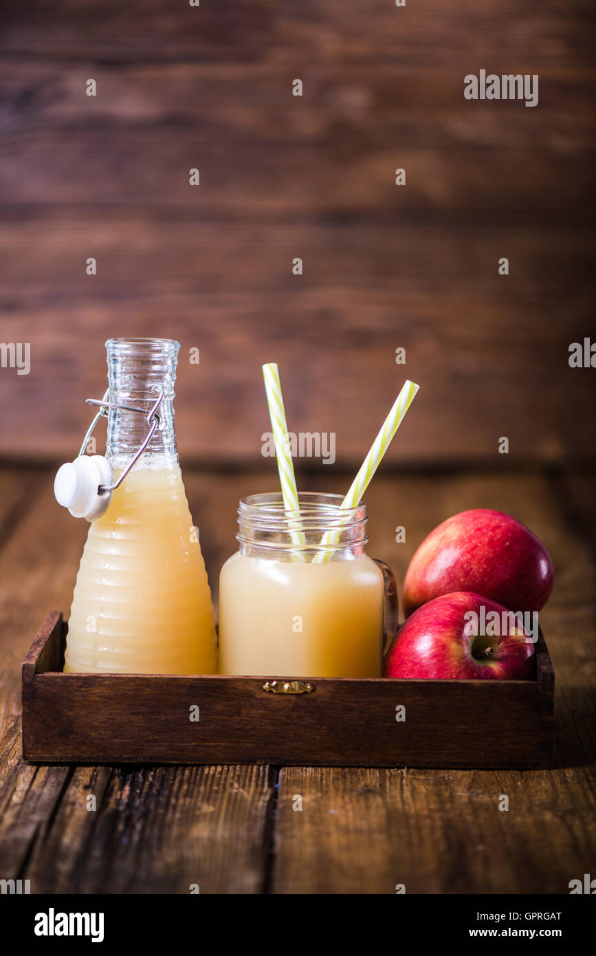 Apple cold pressed juice and fruits in wooden box Stock Photo - Alamy