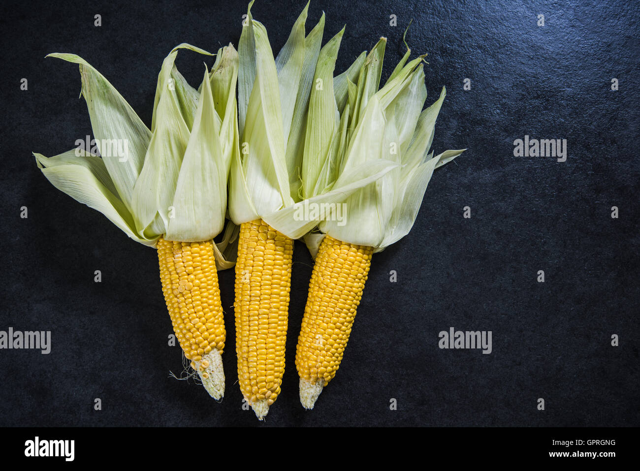 whole corn cobs on dark slate Stock Photo - Alamy