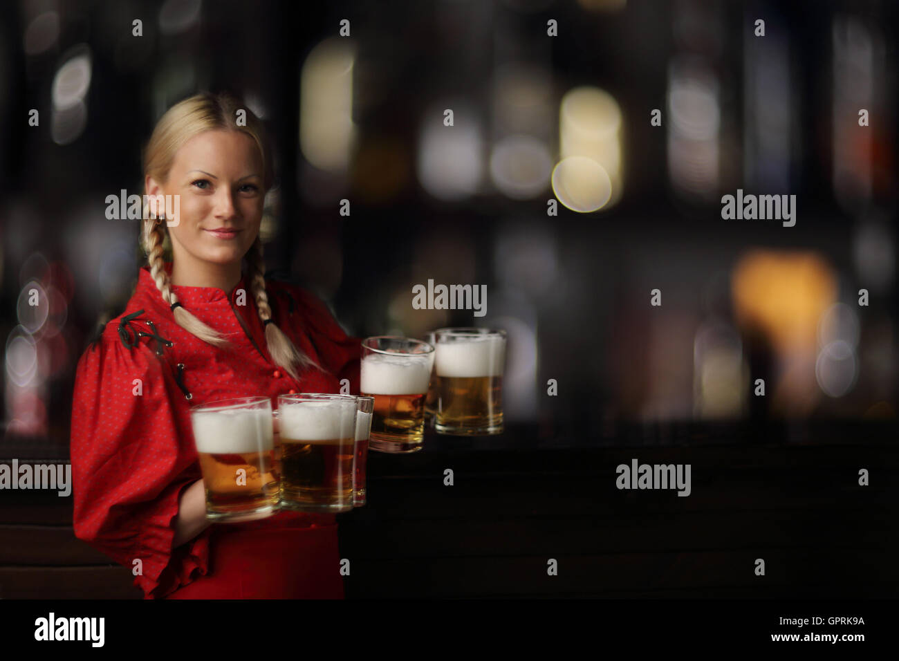 Pretty oktoberfest blonde woman holding beer mugs in bar Stock Photo ...