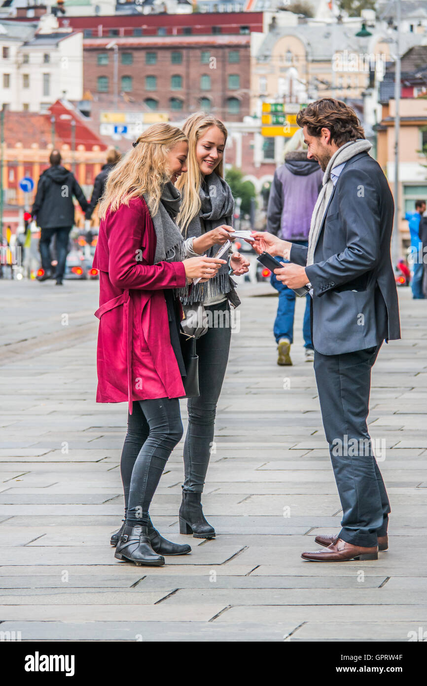A street salesman trying to convince two female potential clients, that ...