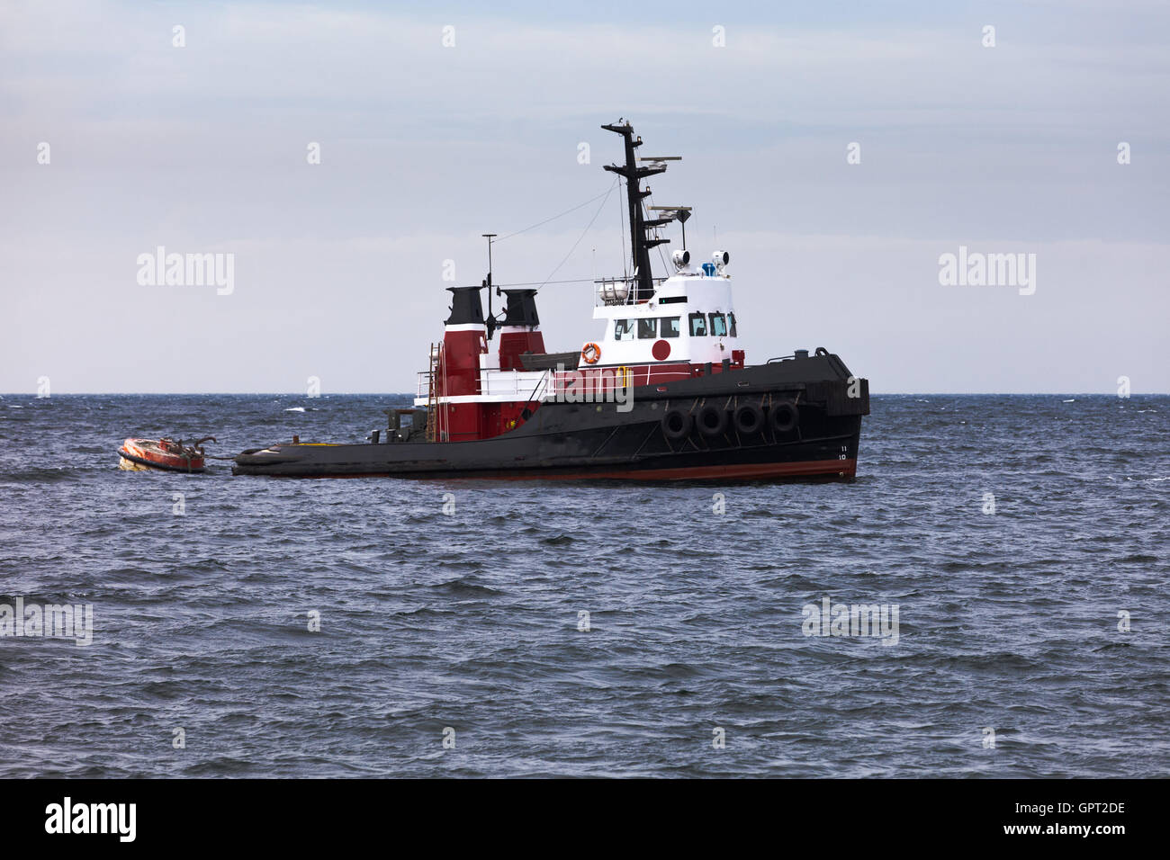 Tugboat floating in wait on calm ocean at anchor Stock Photo - Alamy