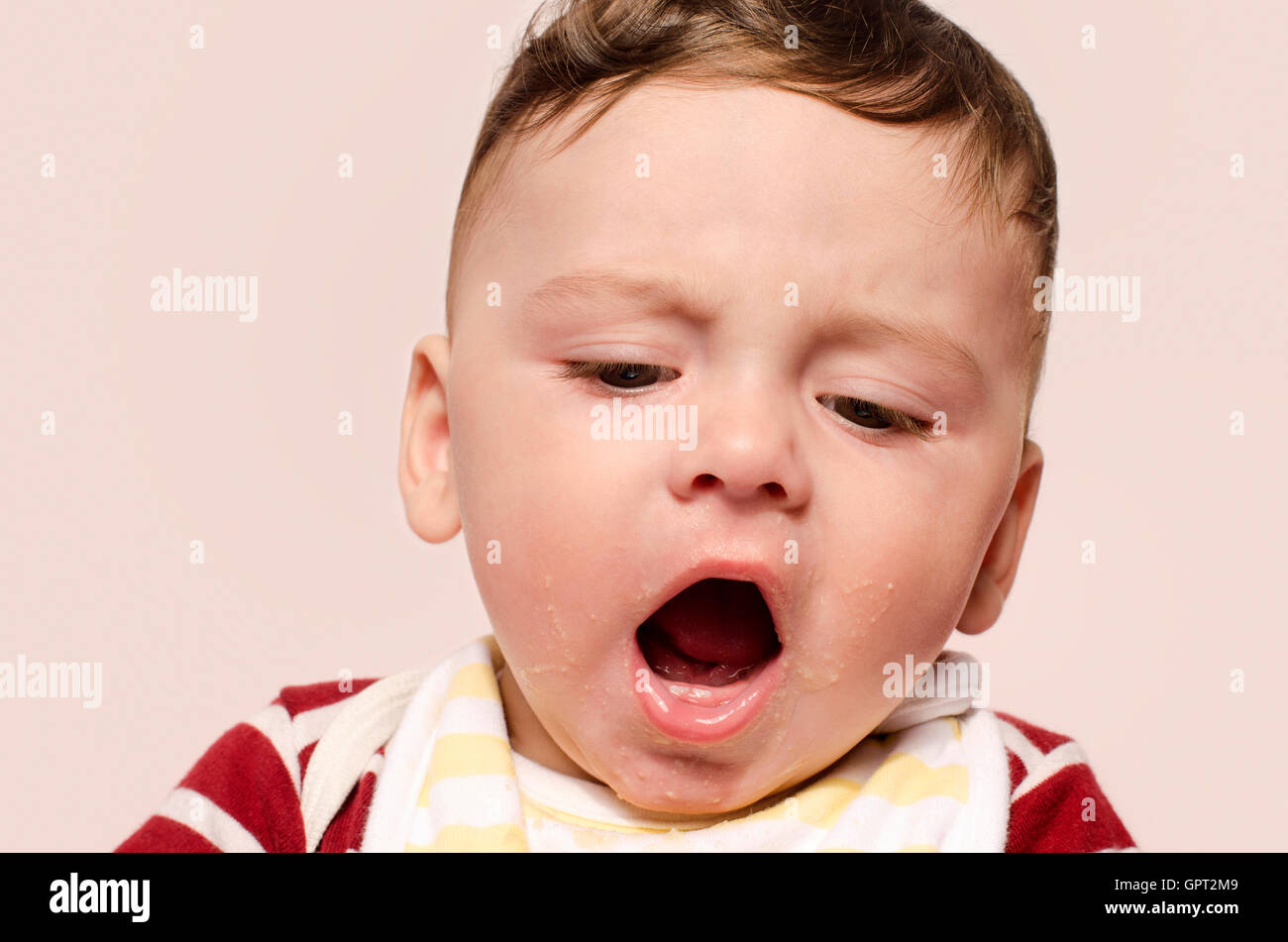 Cute baby screaming refusing to eat baby food Stock Photo - Alamy