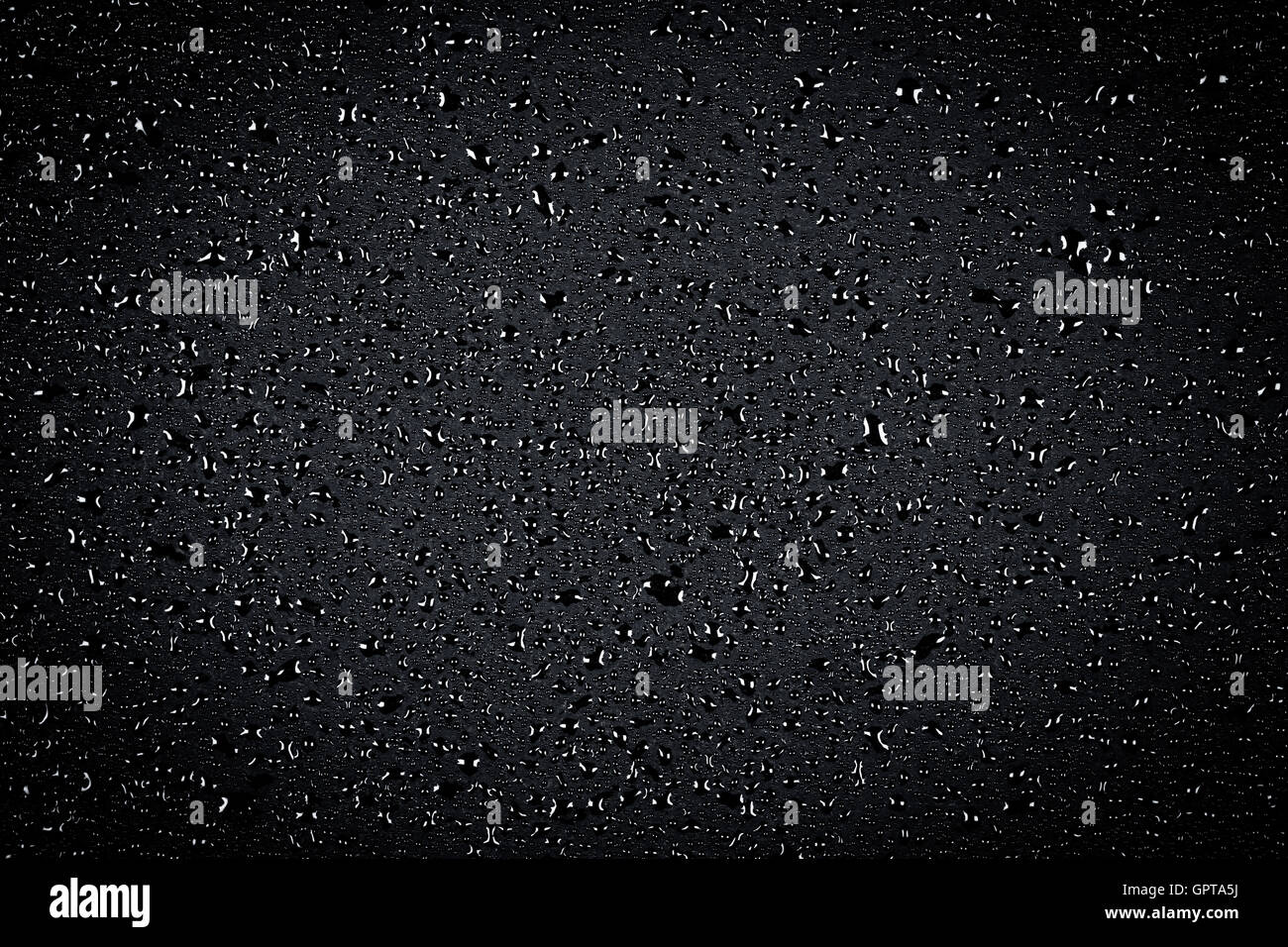 Water drops on dark stone rock surface of basalt or granite Stock Photo ...