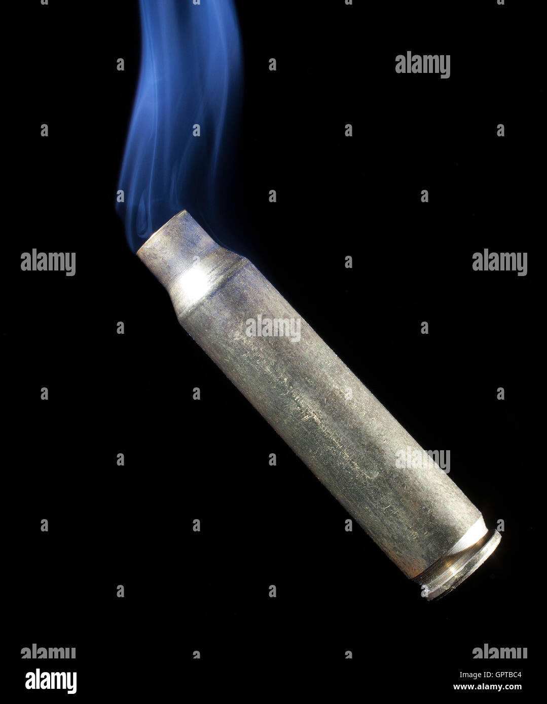Rifle casing that has smoke coming out on a black background Stock ...
