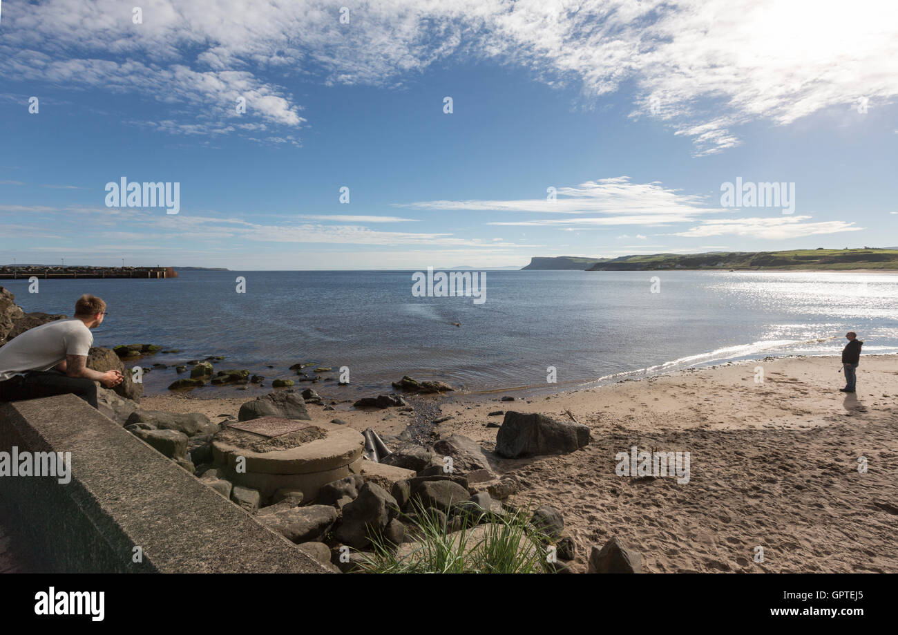 Man observing the sandy beach of Ballycastle, County Antrim, Northern ...