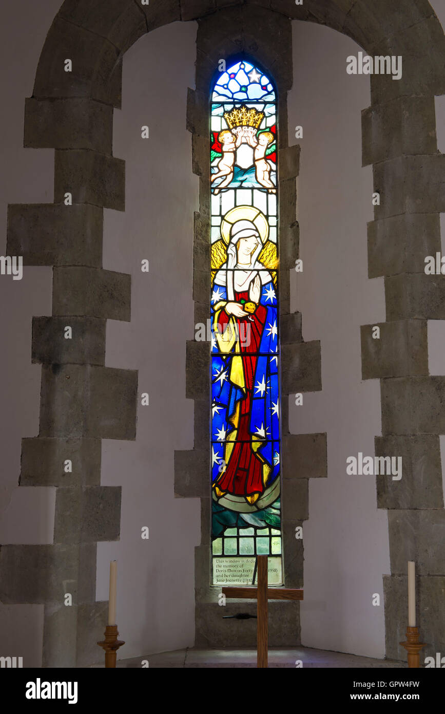 A narrow stained glass window in the church of St Mary and St Peter ...