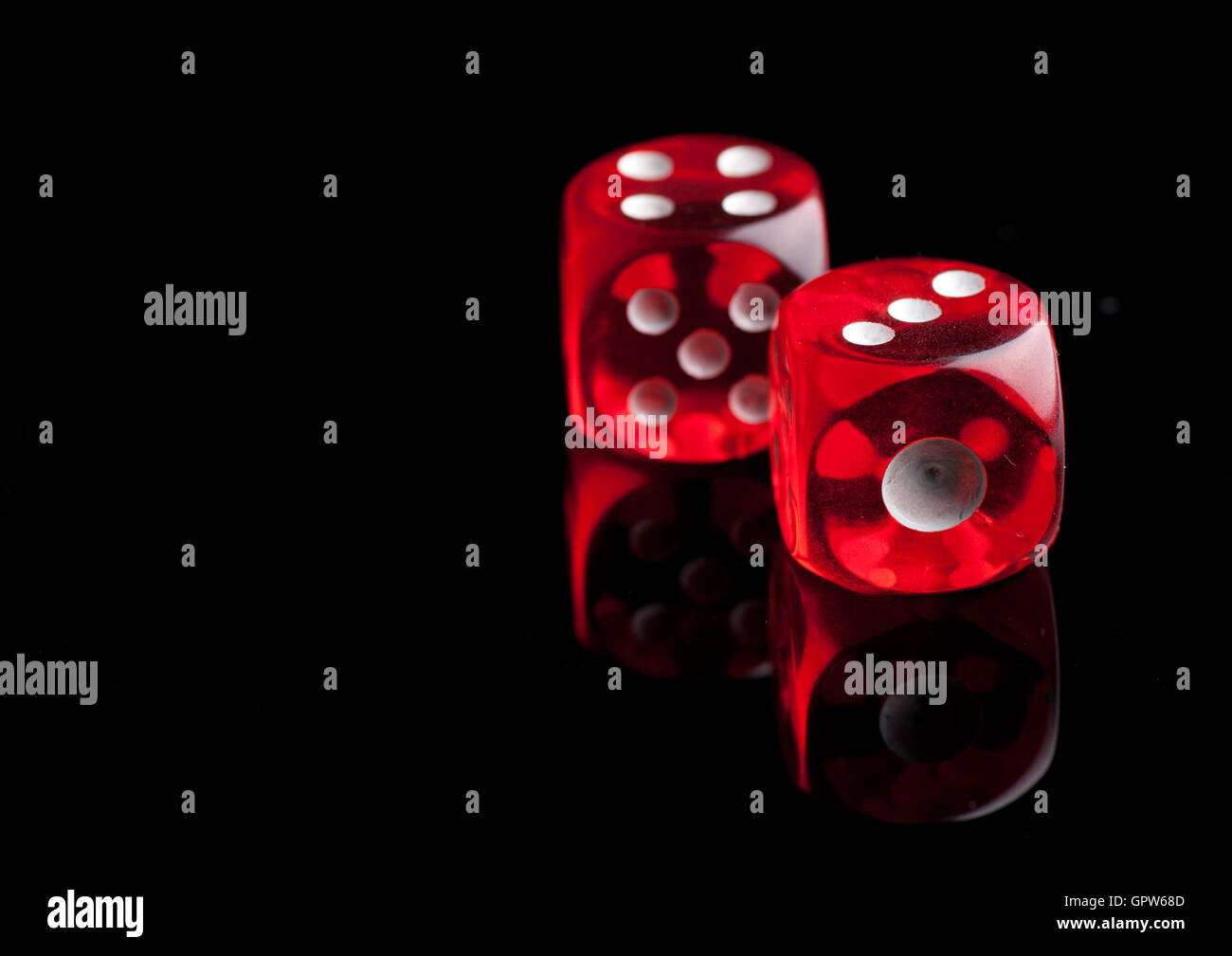 Two red dice on black background Stock Photo - Alamy