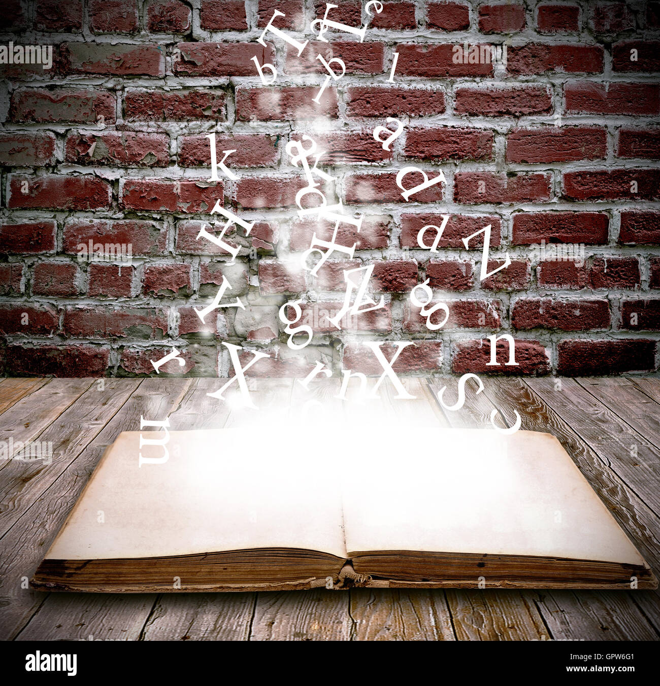 An open book with letters falling into the pages Stock Photo - Alamy