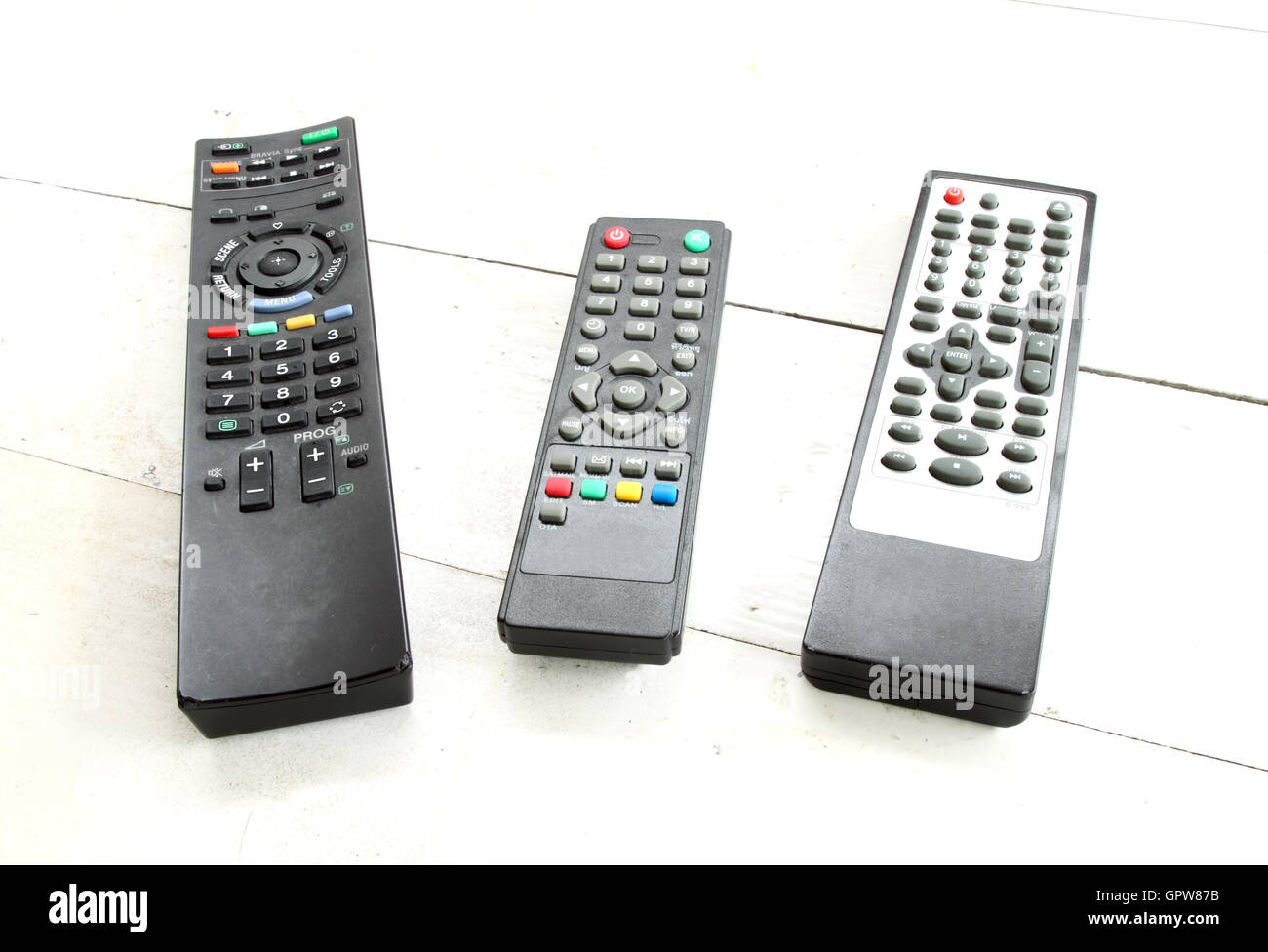 three remote control on white table Stock Photo - Alamy