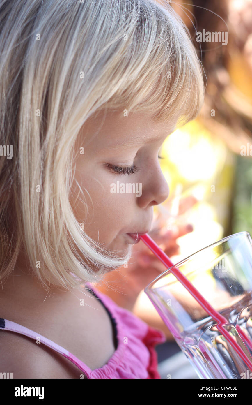 Girl drinking with straw Stock Photo - Alamy