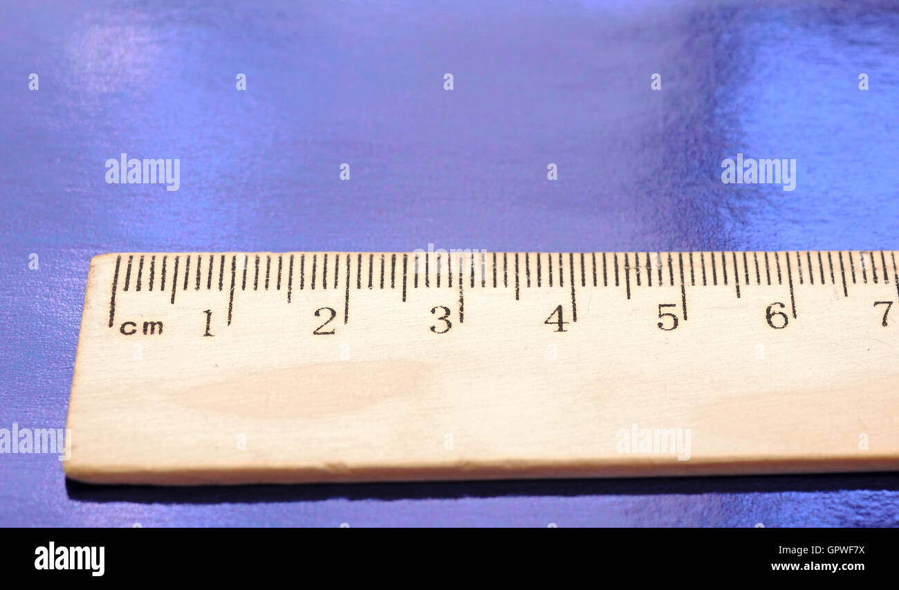 A wood ruler on blue background Stock Photo - Alamy