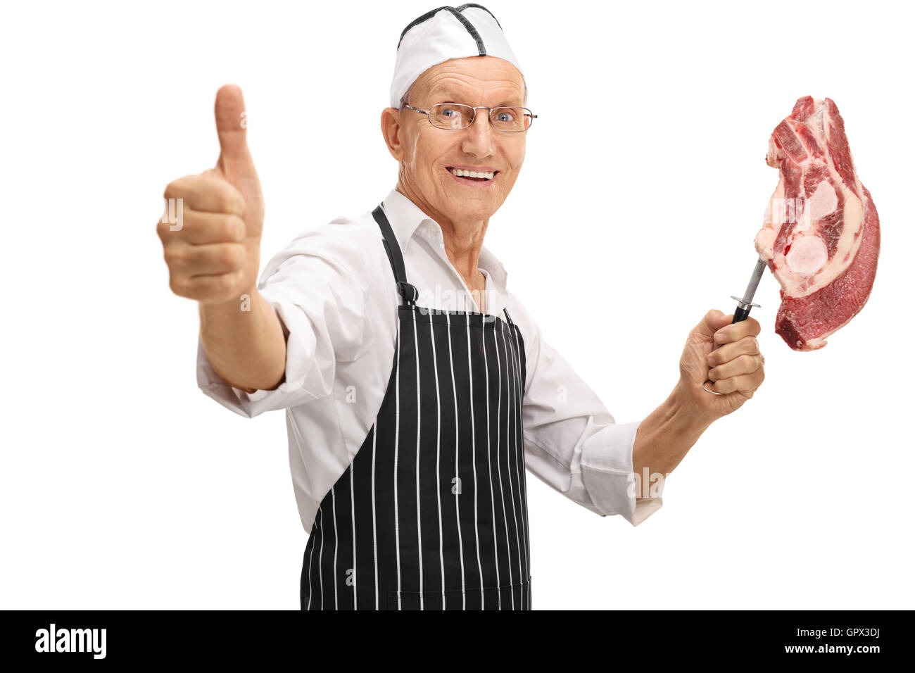 Mature butcher holding a knife with a piece of raw meat on it and ...