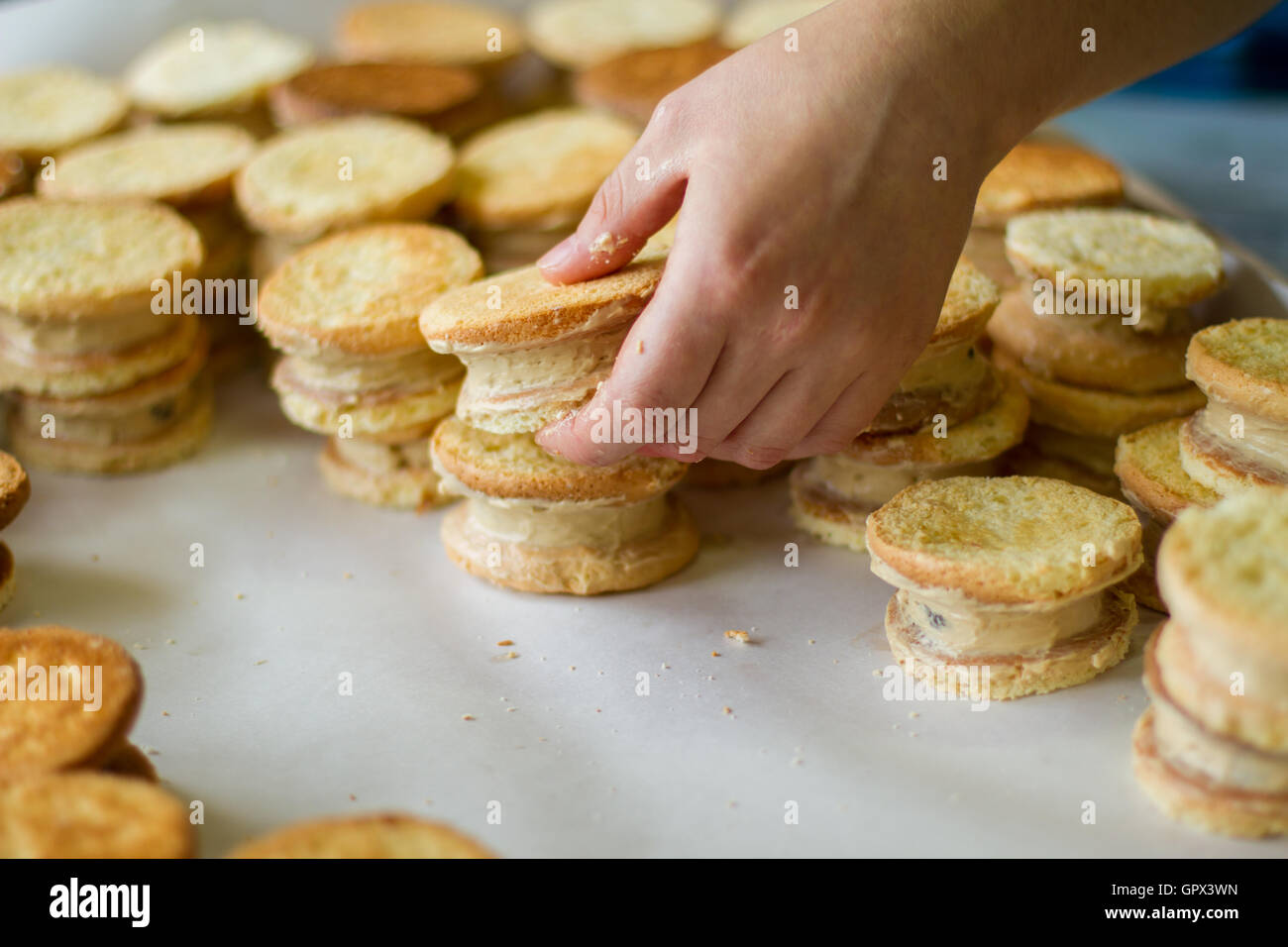 Hand holds biscuits with cream Stock Photo - Alamy