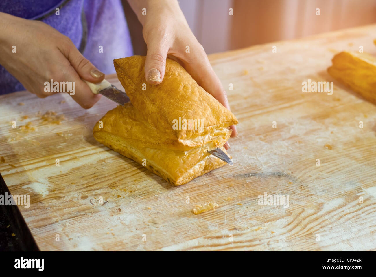 Hand with knife cuts puff Stock Photo - Alamy