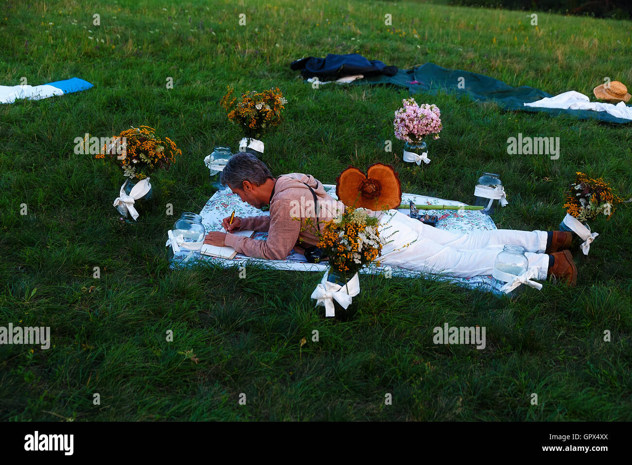 man making a record into a memory book on natural wedding ceremony ...