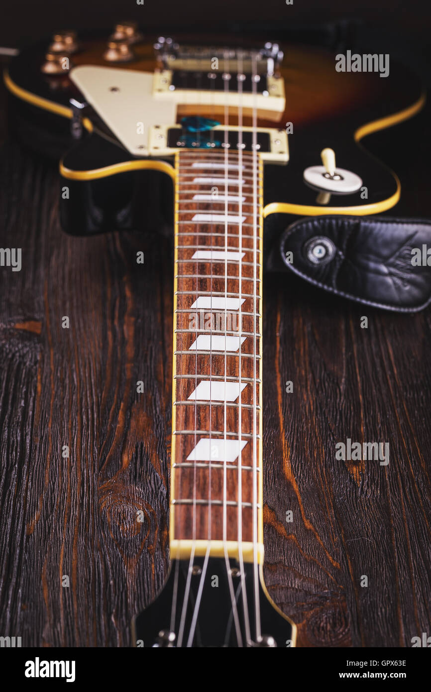Electric guitar fretboard on wooden table close up Stock Photo - Alamy