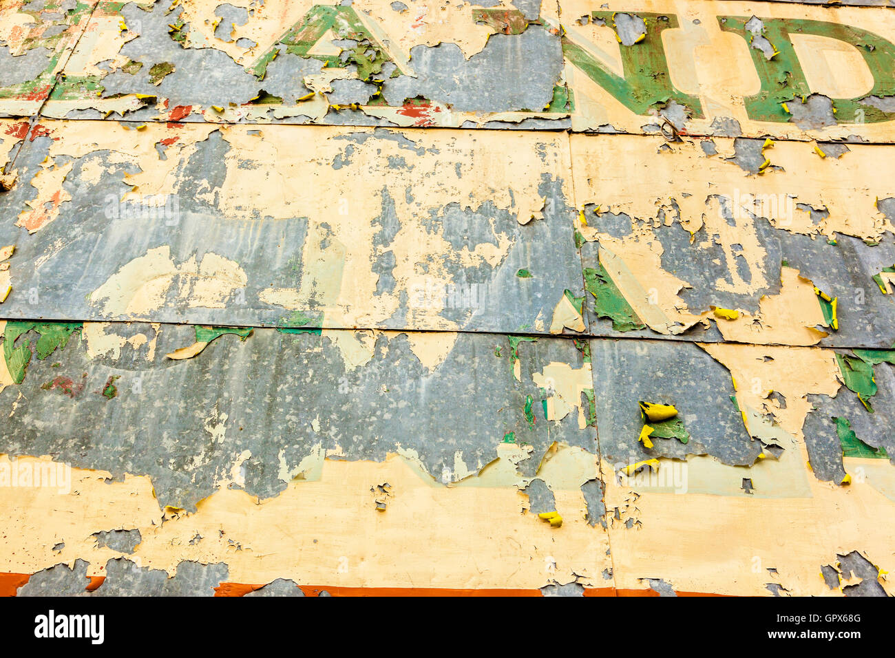 Handpainted letters of a shop signboard faded, peeling and weathered ...