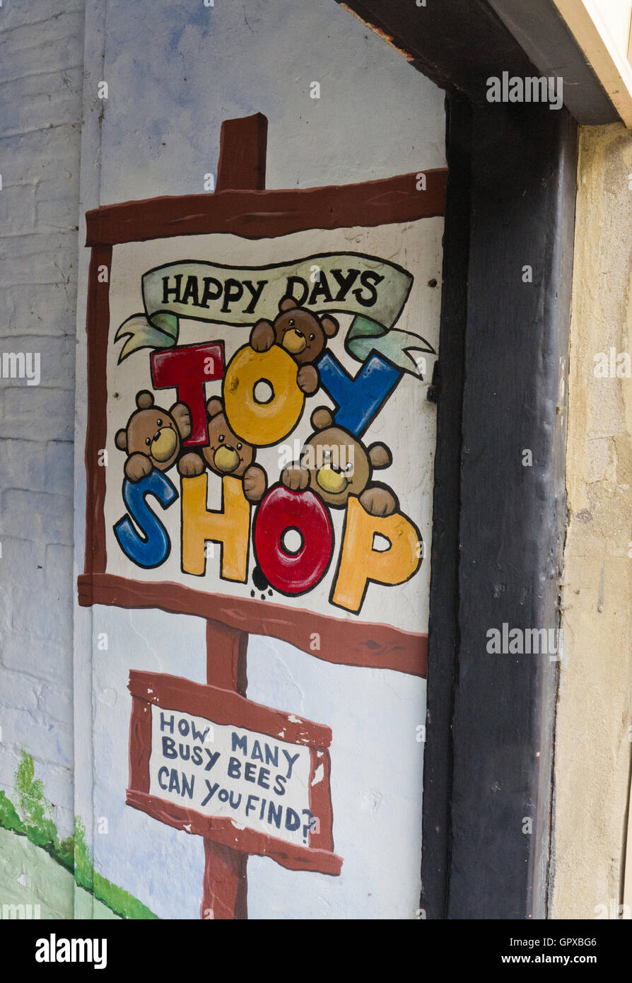 Hand painted sign on a white wall advertising the Happy Days Toy Shop ...