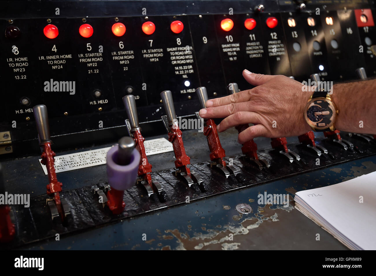 A worker operates a brass lever on a signalling panel inside the Circle ...