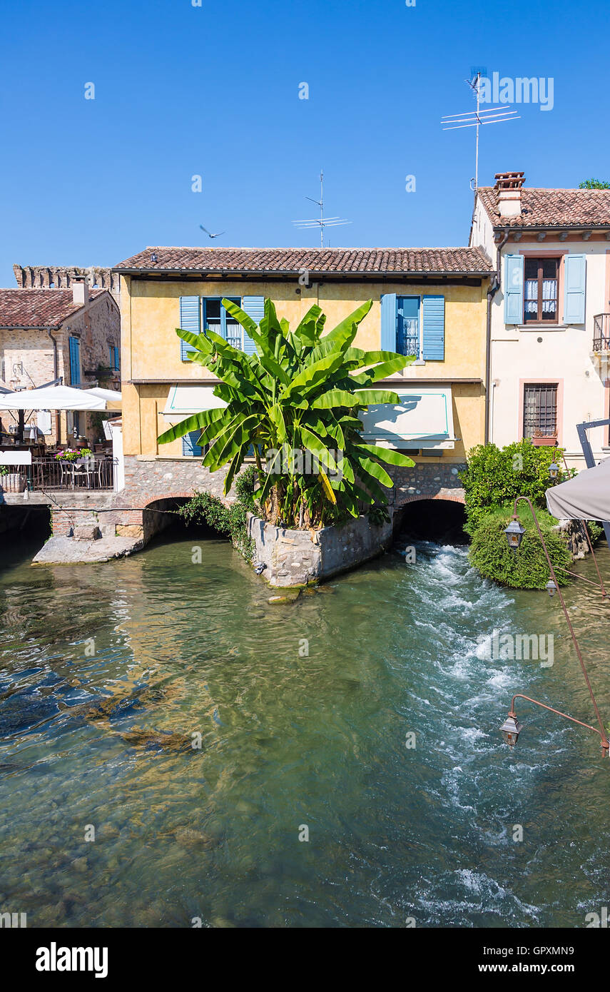ancient buildings of a typical Italian medieval village: the river runs ...