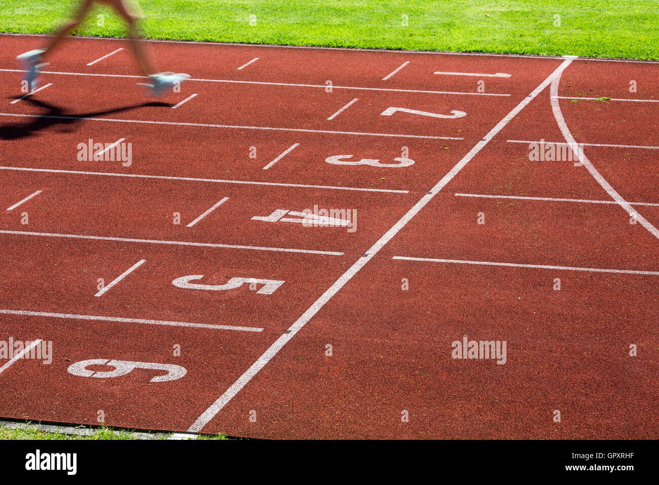 Runner on a running track finishing a race first (motion blurred image ...