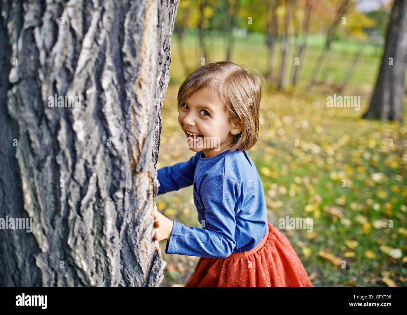Girl Playing Hide and Seek in Park Stock Photo - Alamy