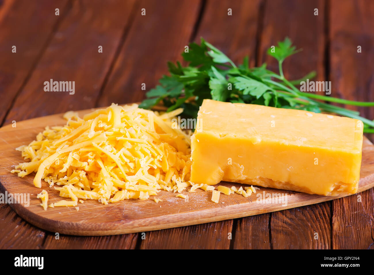 cheddar cheese on board and on a table Stock Photo - Alamy