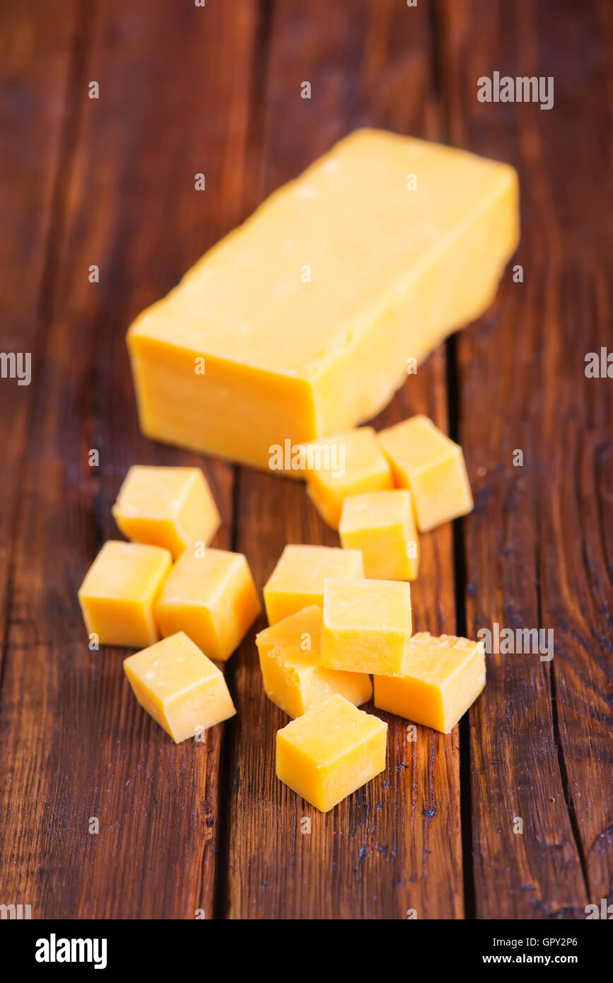 cheddar cheese on board and on a table Stock Photo - Alamy