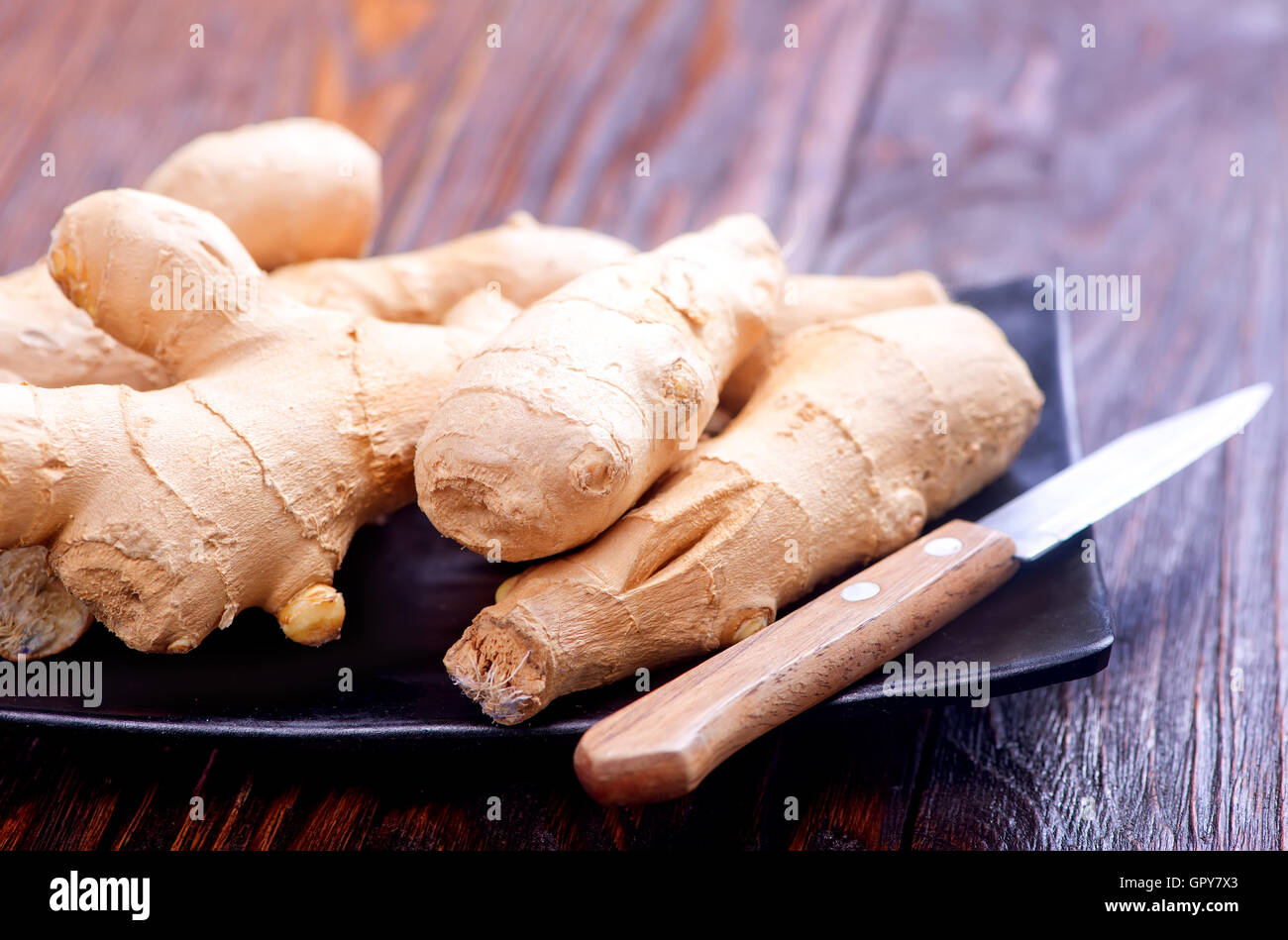 fresh ginger on plate and on a table Stock Photo - Alamy