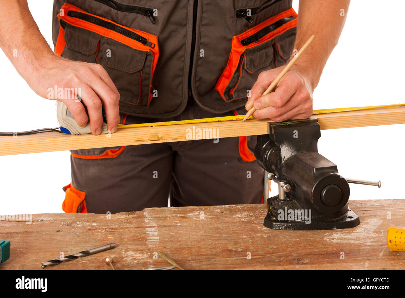 A carpenter measuring a wooden plank in a workshop isolated over white ...