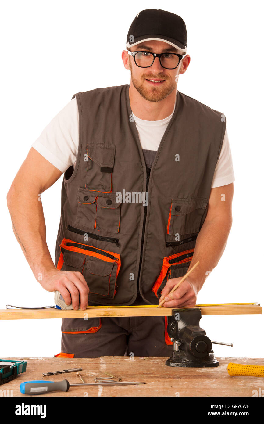A carpenter measuring a wooden plank in a workshop isolated over white ...