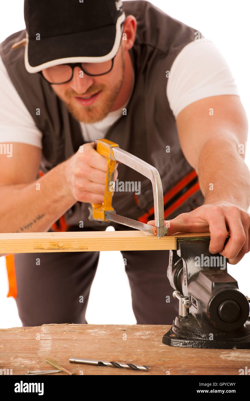 Young carpenter cuts a wooden lath with a saw isolated over white Stock ...