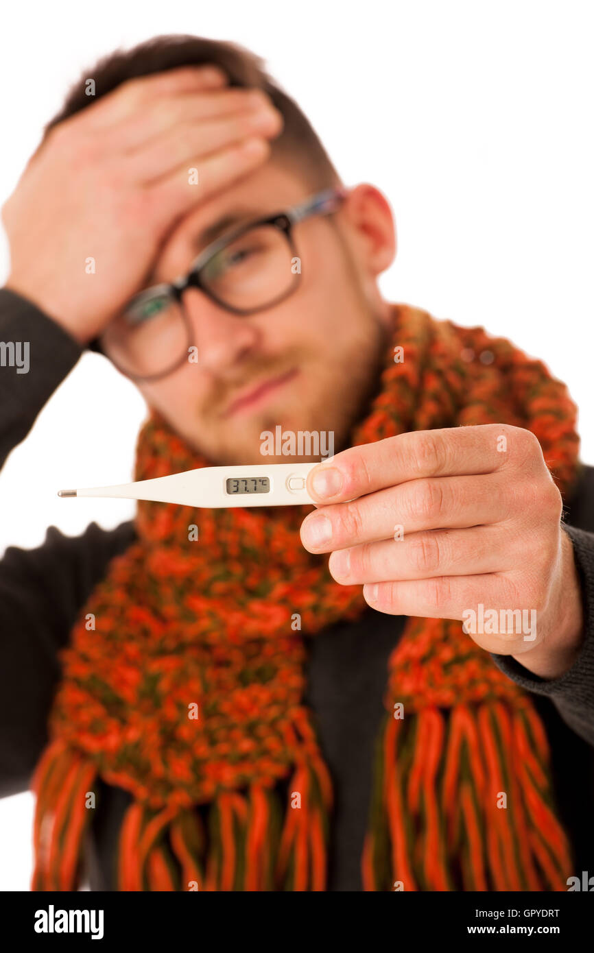 Man with flu and fever wrapped in scarf holding thermometer isolated ...