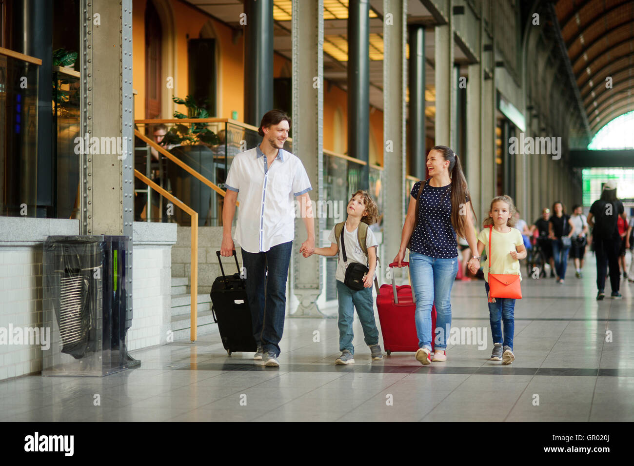 Young family with two children at train station. The family passes ...
