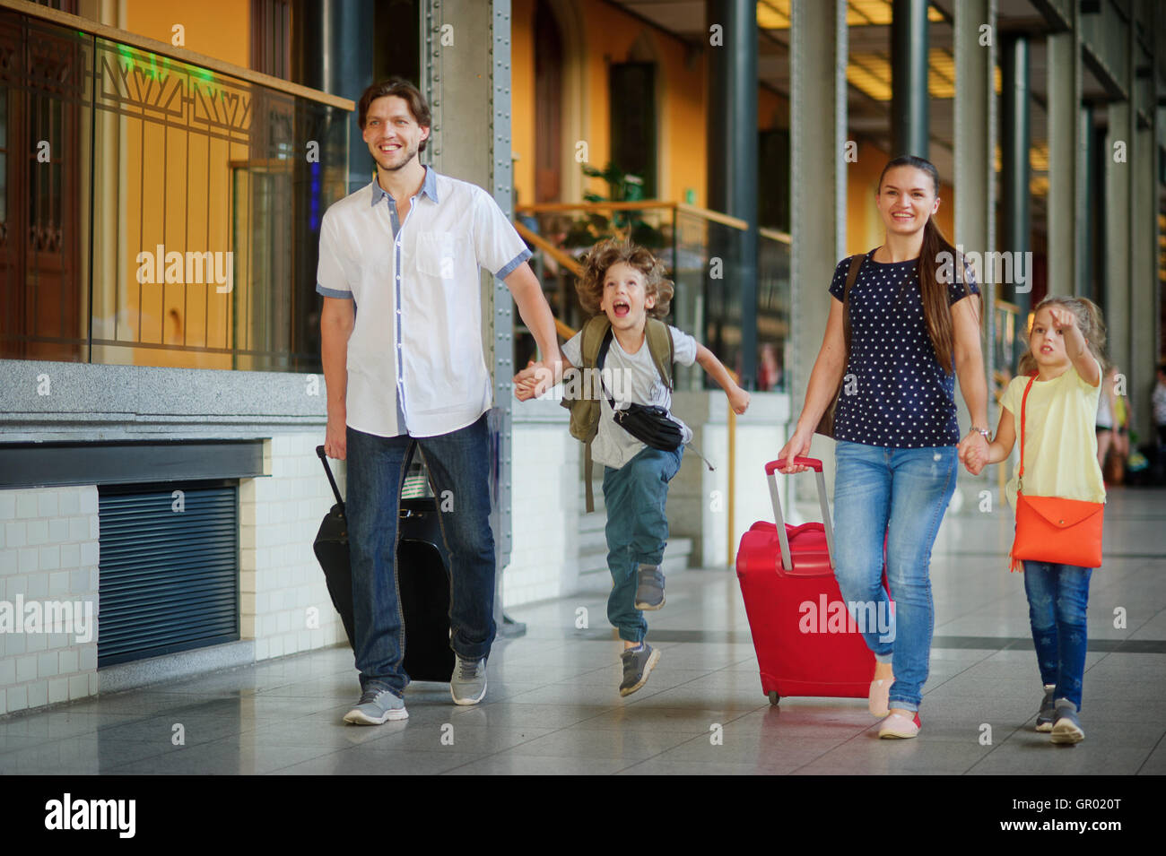 Young family with two children at train station. The family passes ...