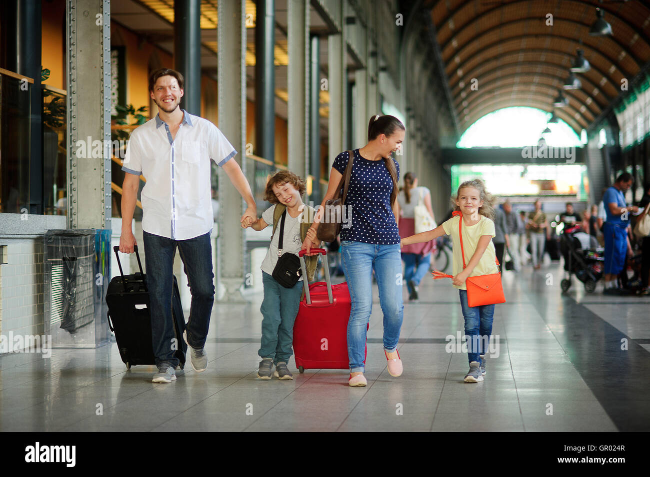 Young family with two children at train station. The family passes ...