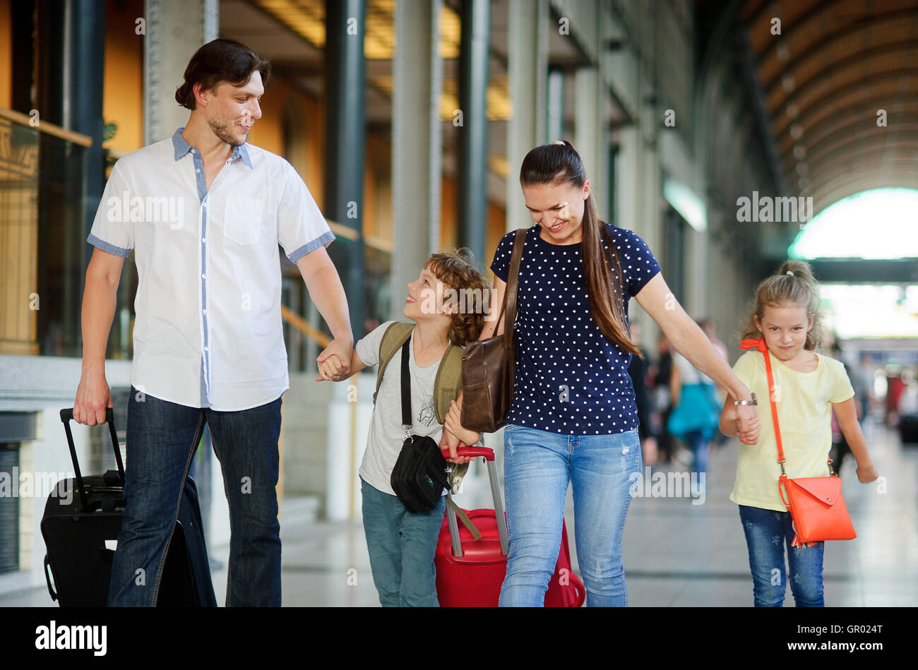 Young family with two children at train station. The family passes ...