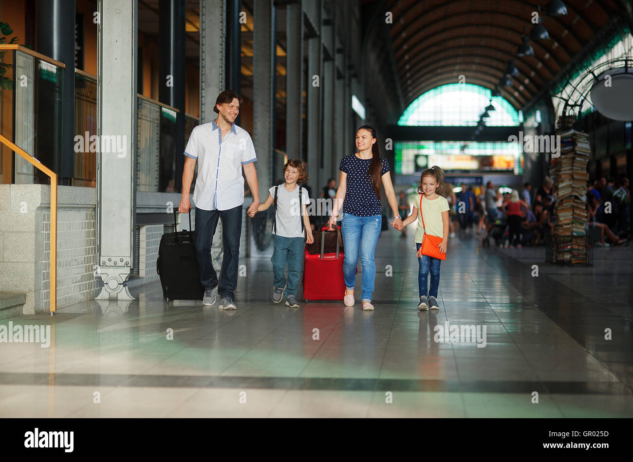 Father, mother and two children pass the waiting room at the station ...