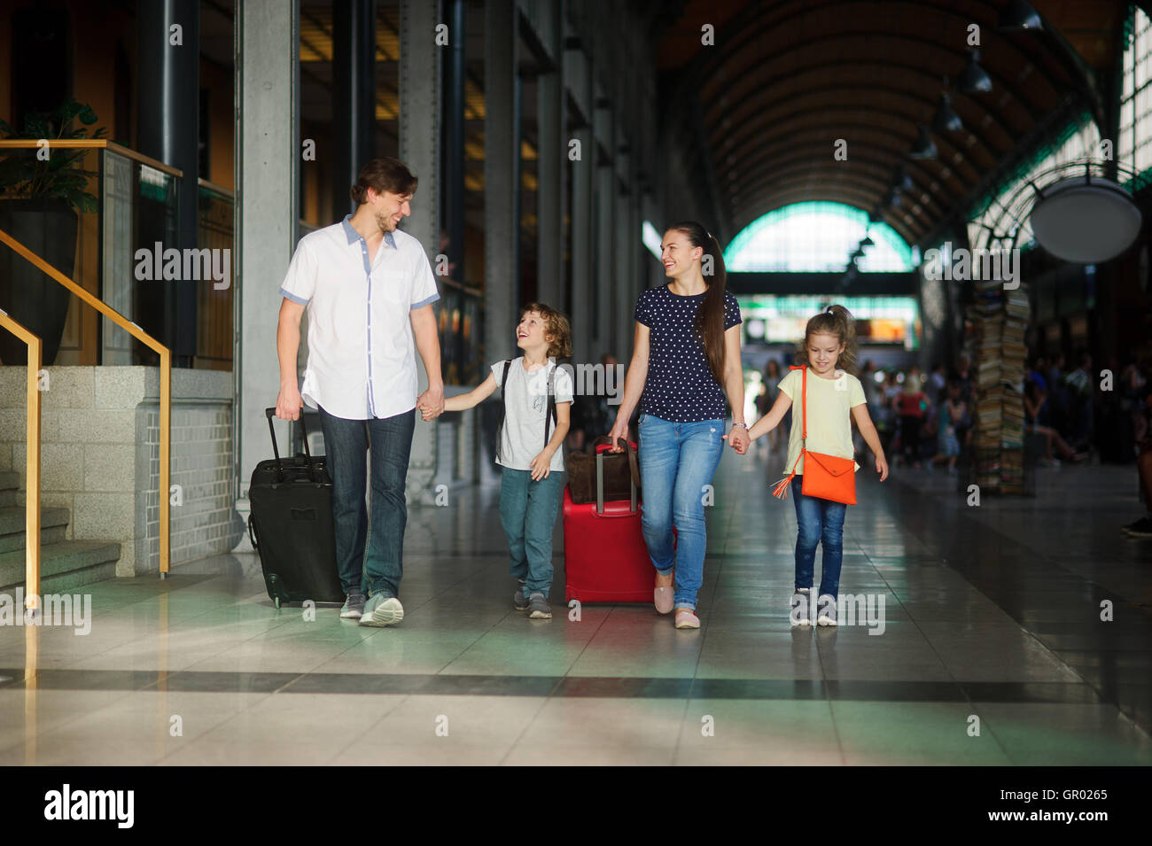 Young parents with a daughter and a son go through the waiting room at ...